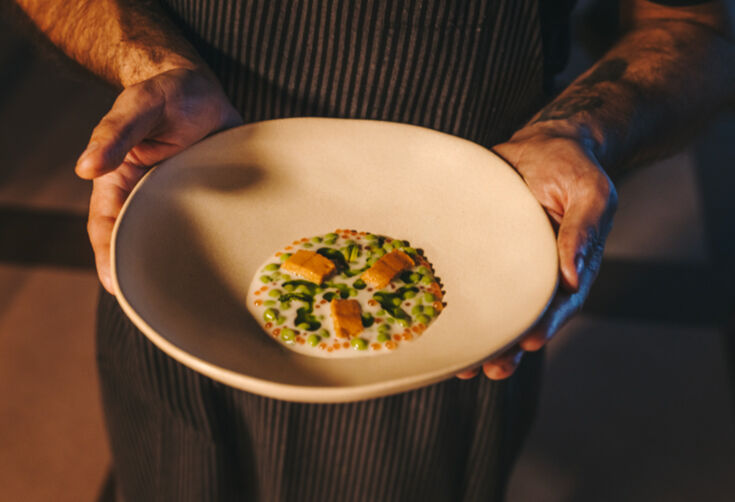 Sentados a la mesa, los comensales degustan gastronomía local del chef ...